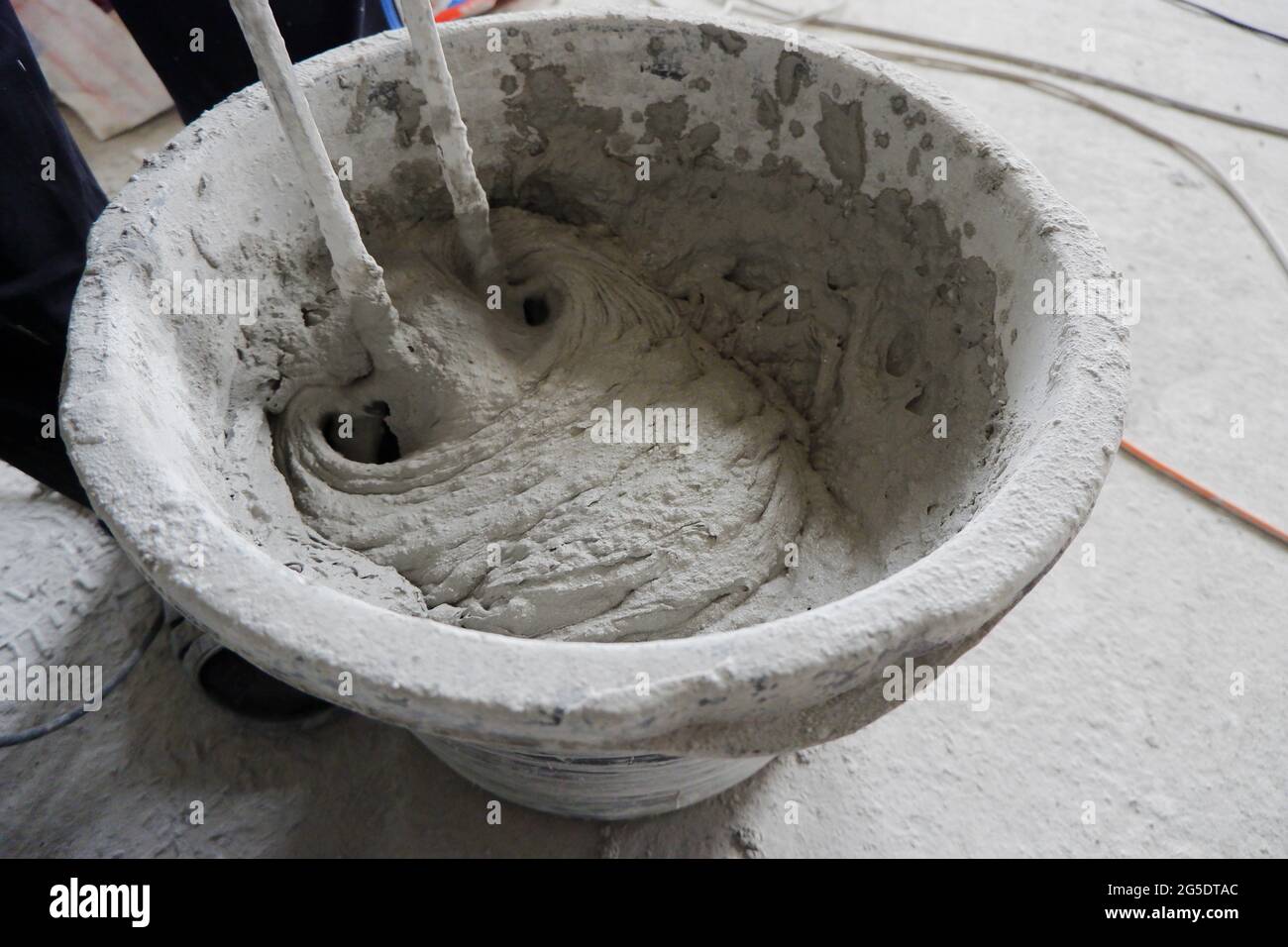 the builder mixes the construction mixture in a container for guiding ...