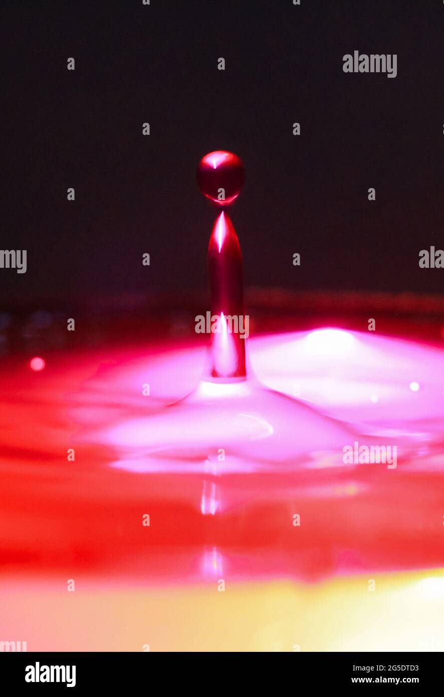 close up of colorful water droplets falling. Waterdrop splash into the ...