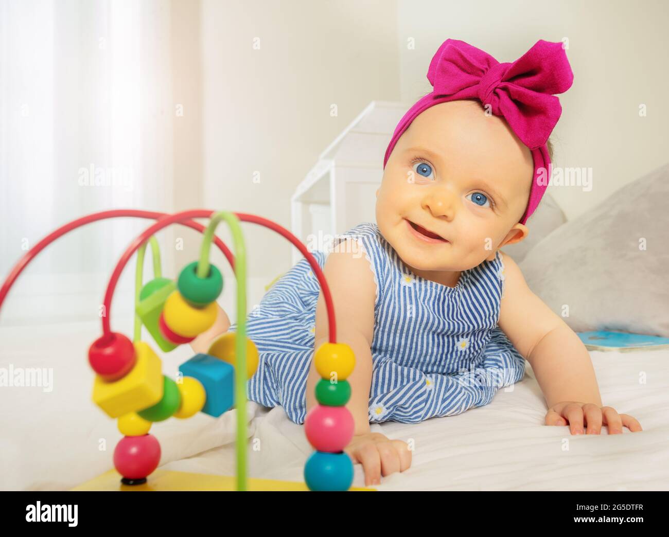 Infant girl play with bead roller coaster toy Stock Photo - Alamy