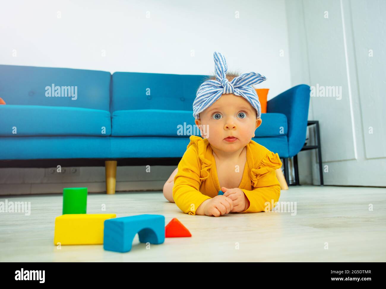 Baby girl play with color blocks in living room Stock Photo - Alamy
