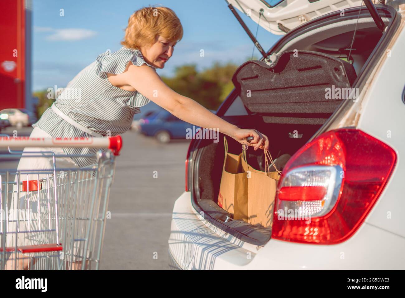woman putting paper bags with food in car trunk Stock Photo - Alamy