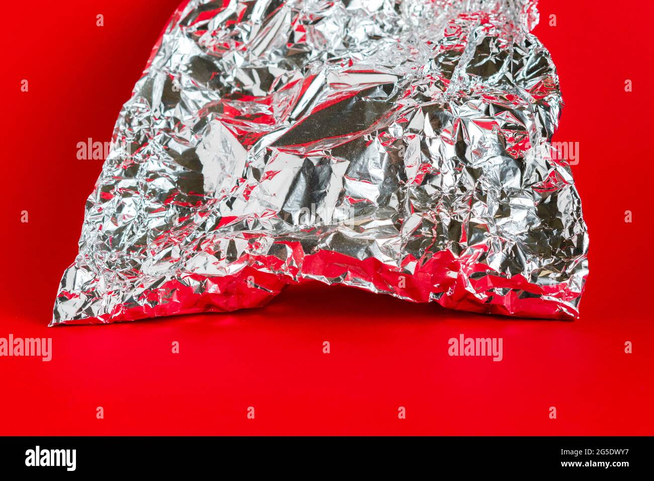 a piece of crumpled foil on color surface Stock Photo - Alamy