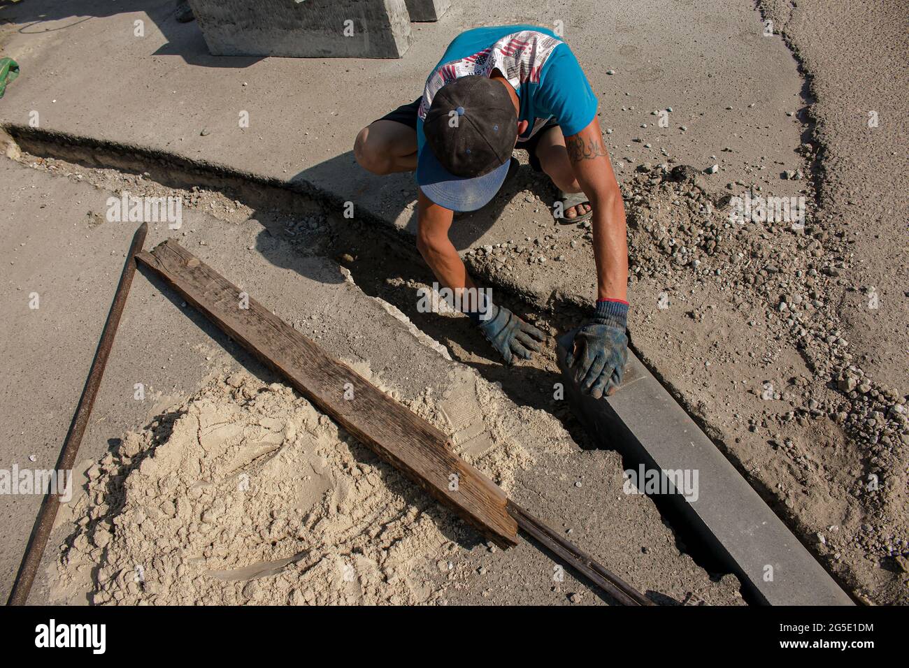 The process of laying the sidewalk curb. Workers prepare a trench for ...
