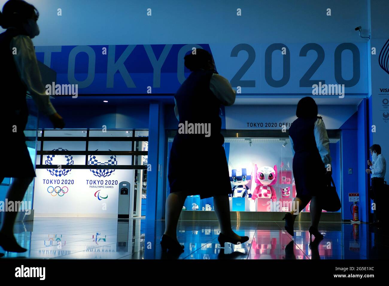 People walk past the Official Tokyo Olympic Shop at Haneda Tokyo ...
