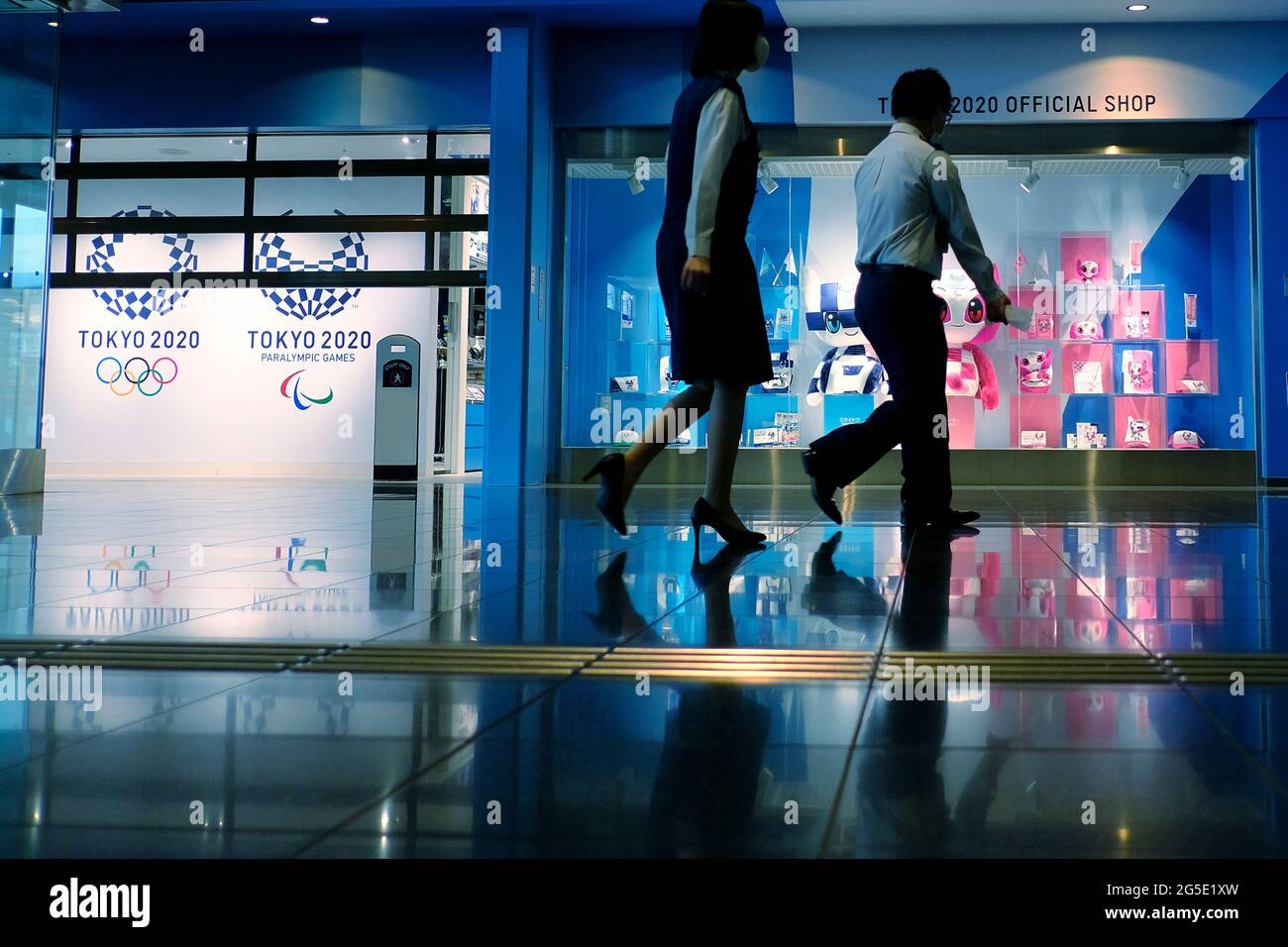 People walk past the Official Tokyo Olympic Shop at Haneda Tokyo ...