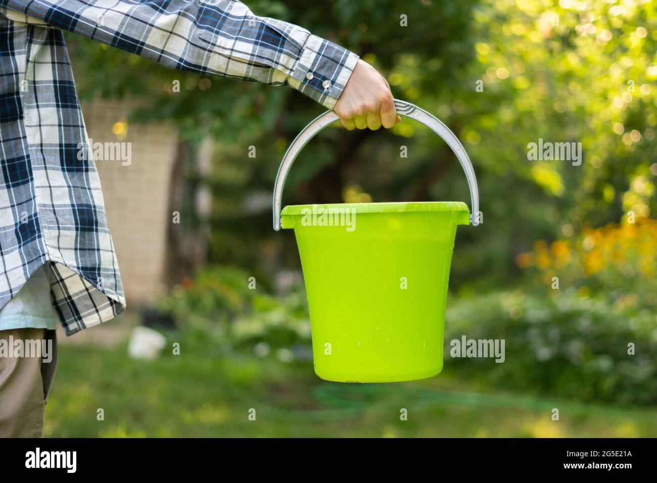 holding a color plastic bucket with pure water Stock Photo - Alamy