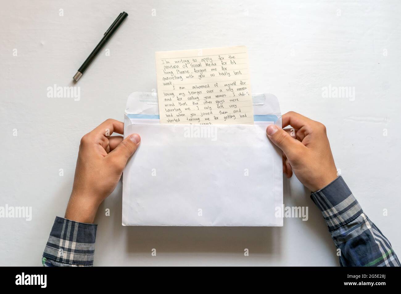 person put a paper into the envelope to send it to friend, top view ...