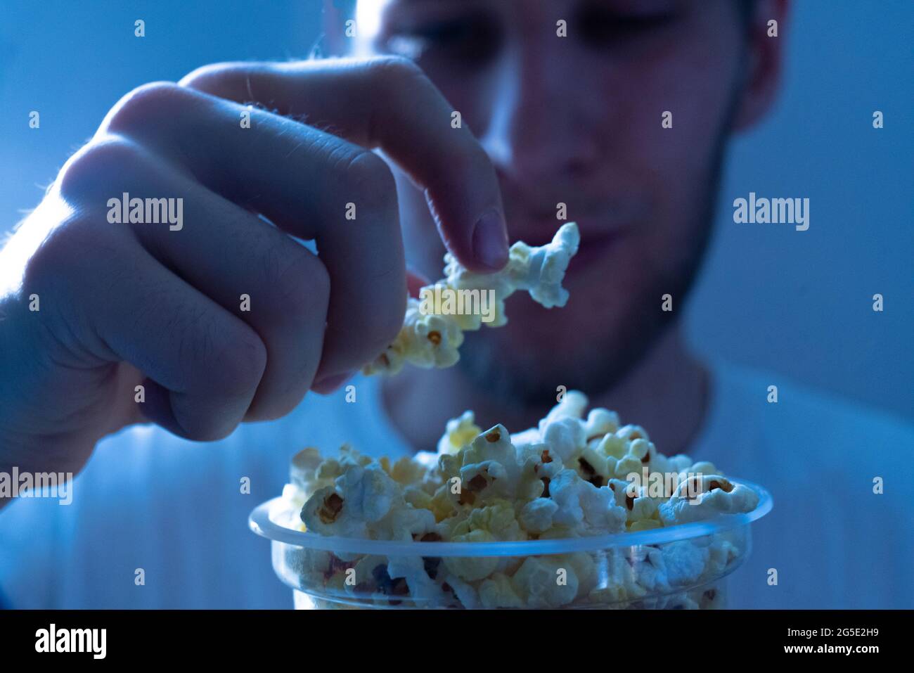 close up young male holding popcorn to put it in his mouth Stock Photo ...