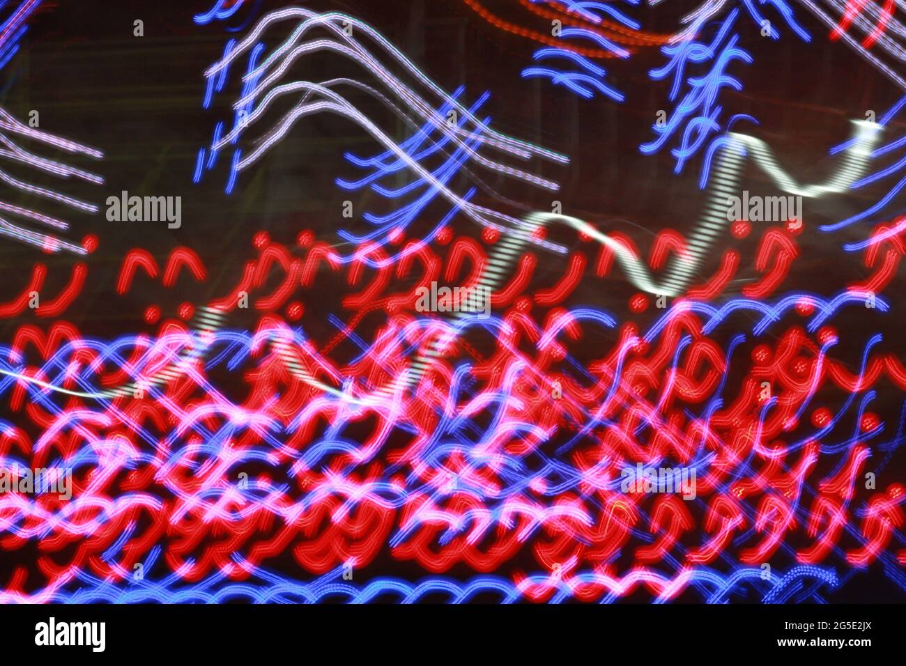 Sparkling intersecting light paths with festive lighting at night. Long ...