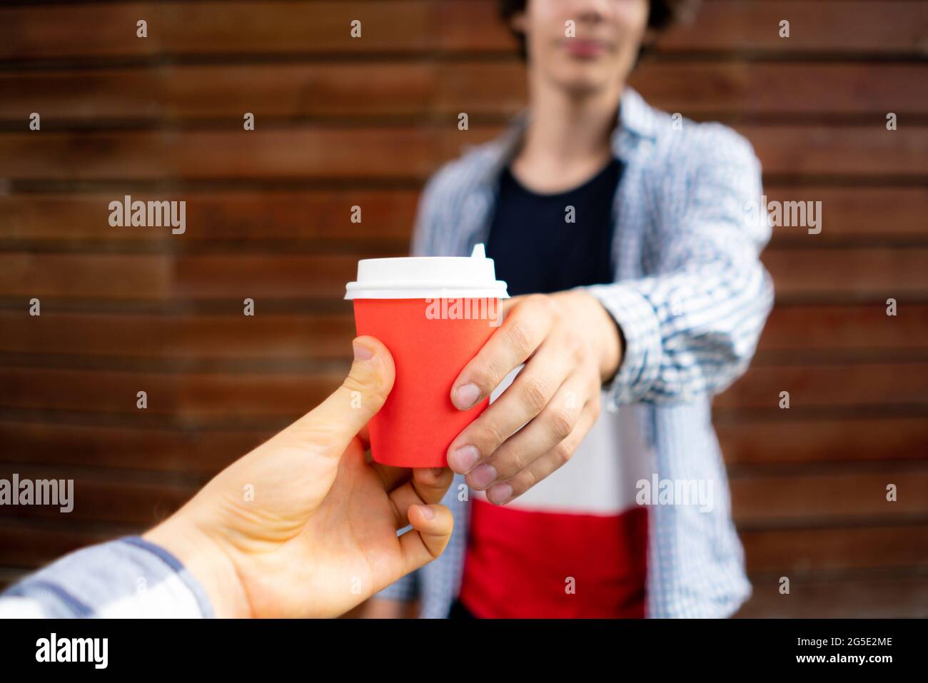 giving a cup of fresh hot espresso, two hands deliver and recieve ...