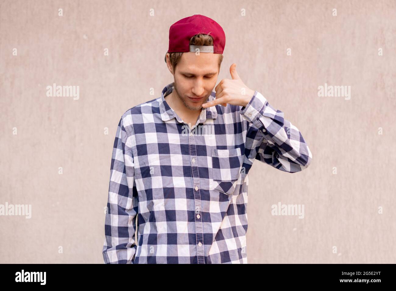 young guy showing a call me sign gesture finger, symbol of mobile phone ...