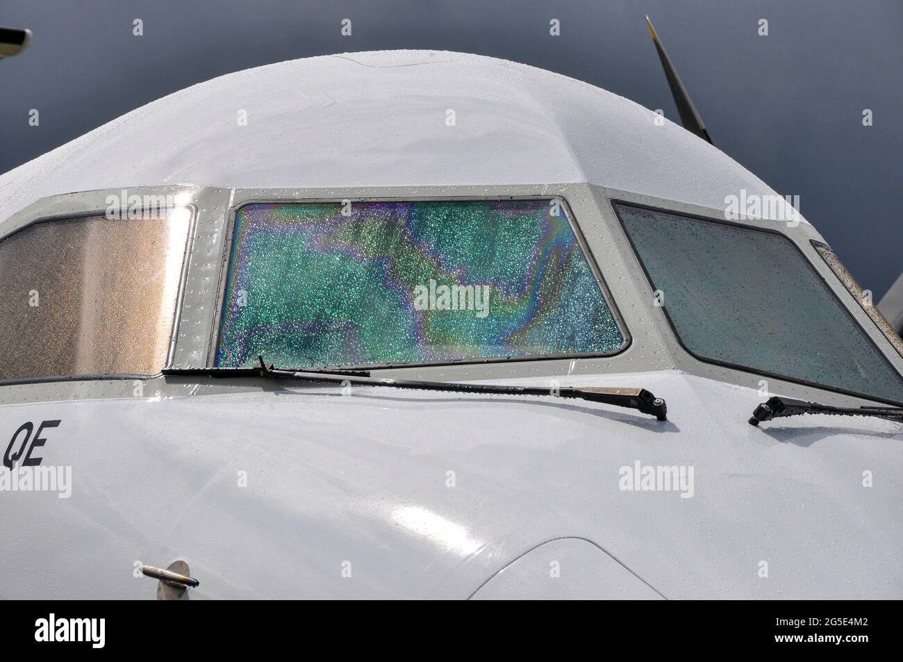 Cockpit window of a business jet plane, wet from the rain at the ...
