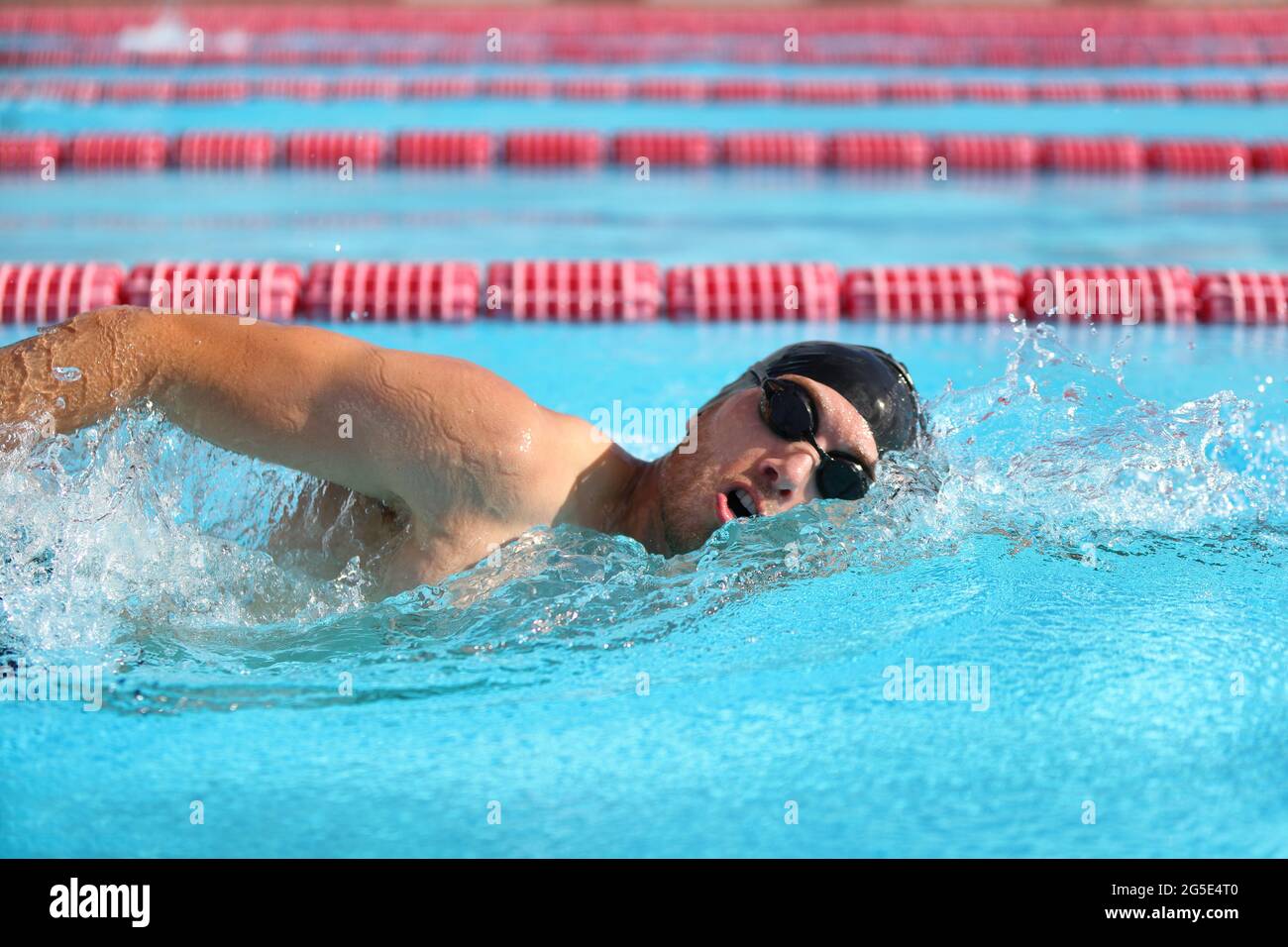 Swimmer man athlete swimming in pool lanes doing a crawl lap. Swim race ...