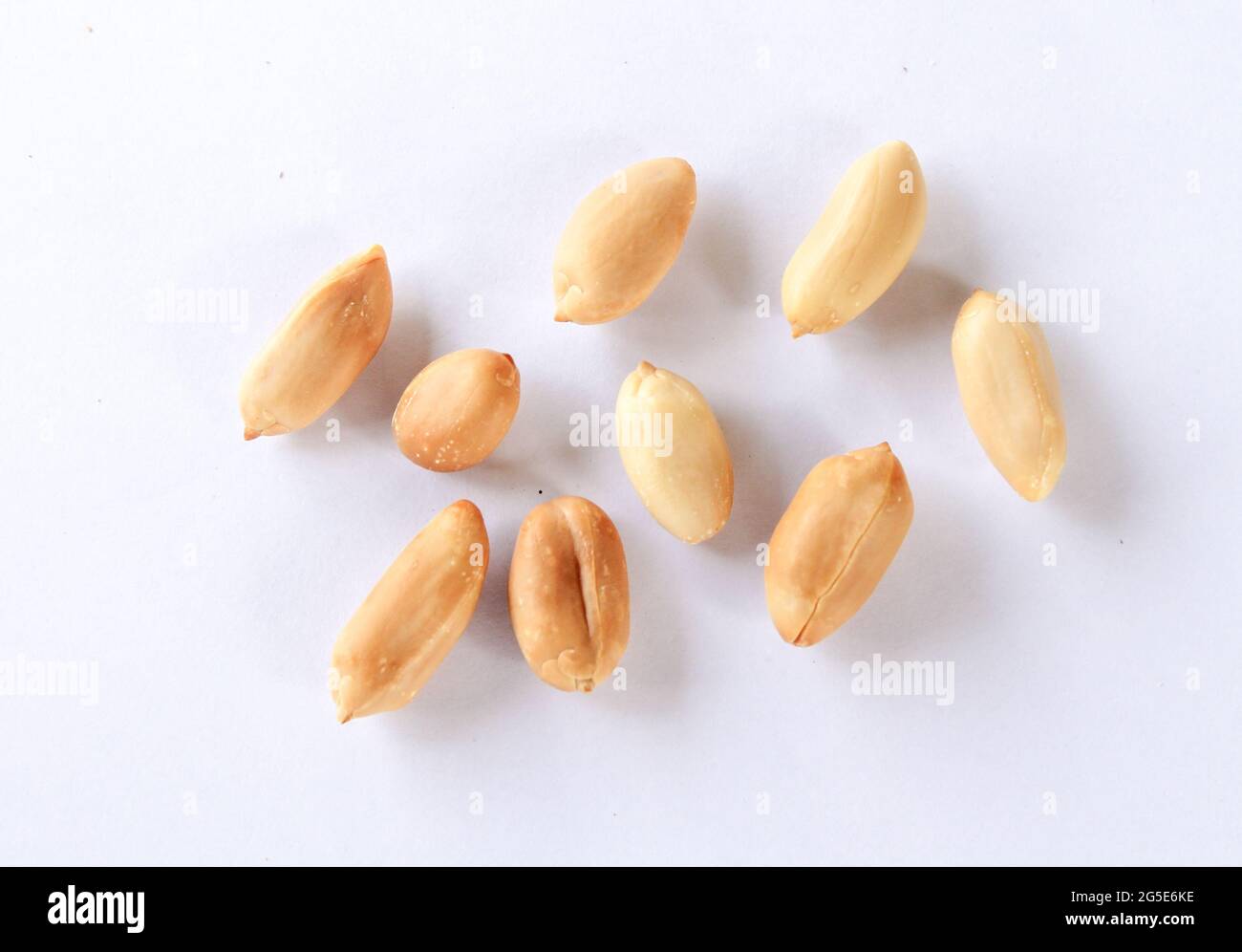 peeled peanuts scattered on a white background Stock Photo - Alamy