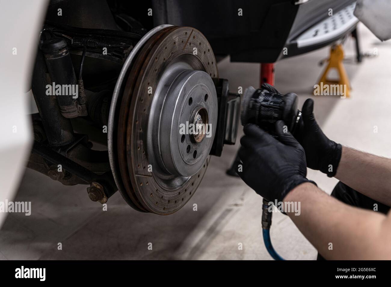 Mechanic repairing car brakes in service Stock Photo - Alamy