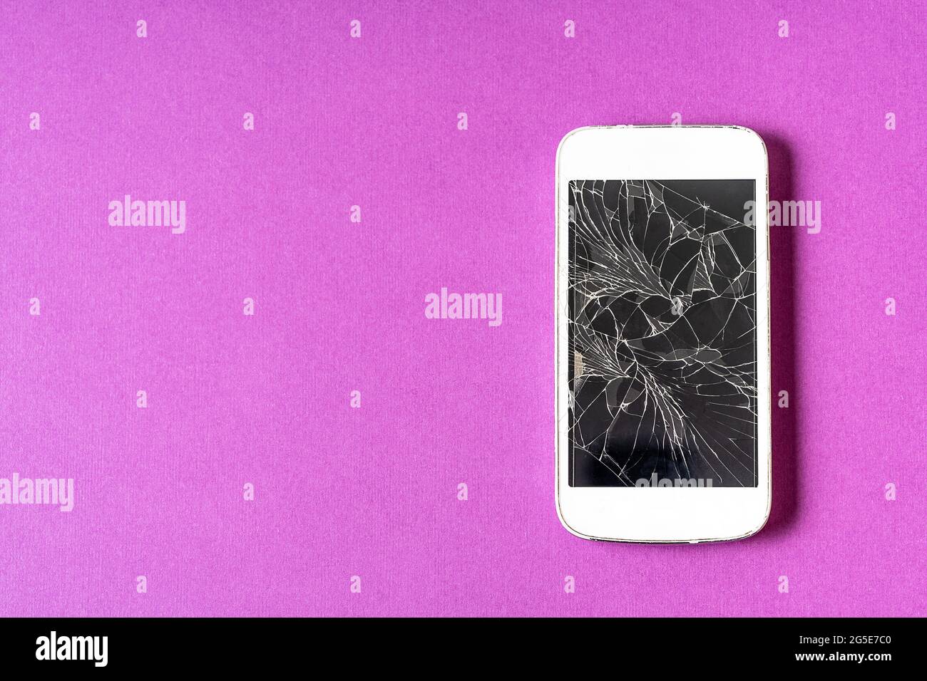 Broken mobile phone with cracked display on purple background, flat lay ...