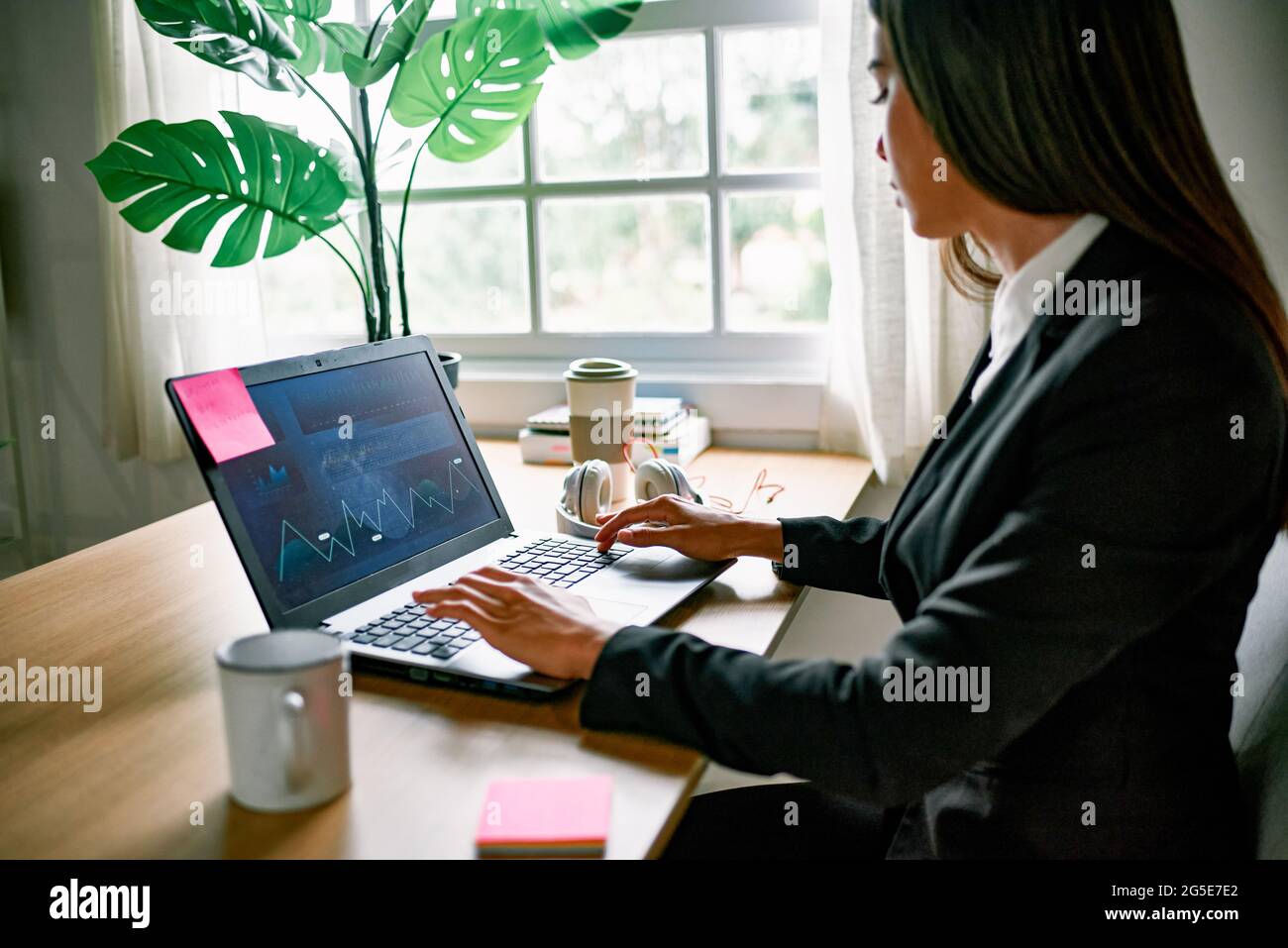 Young business woman working on laptop computer inside bank office ...