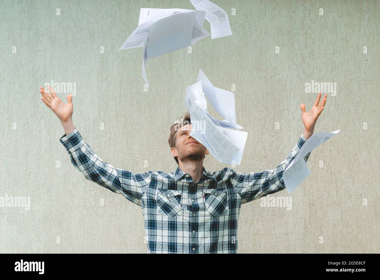 young stressed man throw crumpled paper files in the air, freedom ...