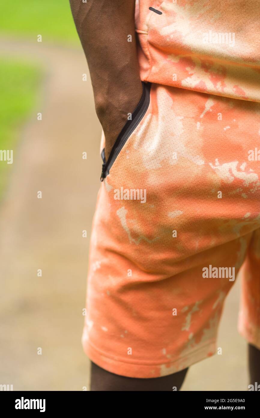 Leg of a black man wearing orange short Stock Photo - Alamy