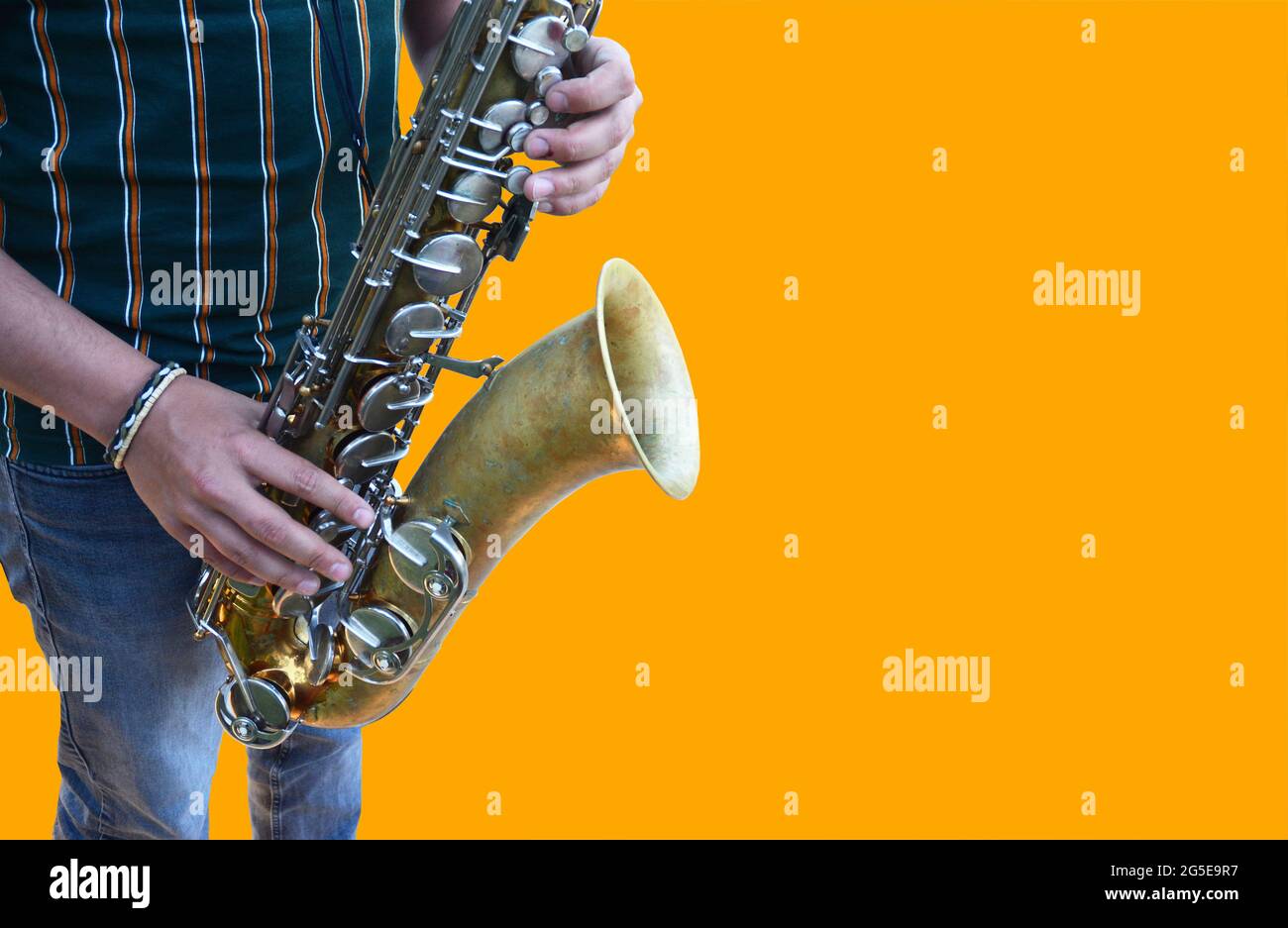 a detail of a saxophone isolated on a orange background Stock Photo - Alamy