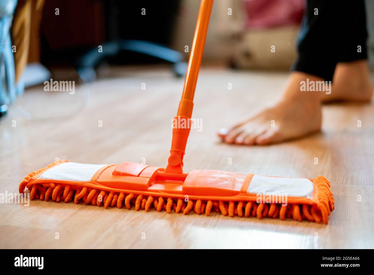 single man holding a mop and cleaning the laminate floor at home Stock ...