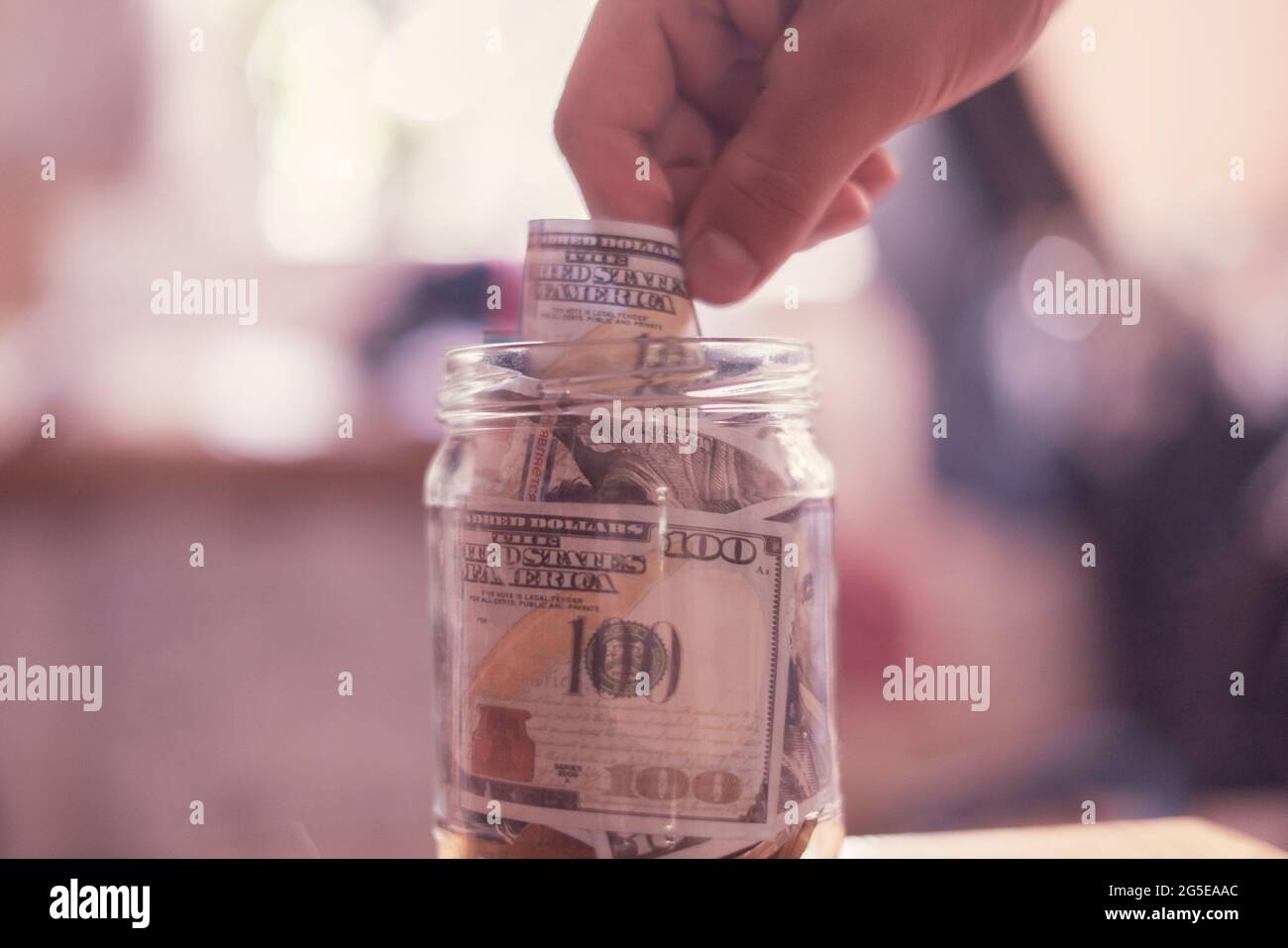 hand put some money in the glass bank with savings Stock Photo - Alamy