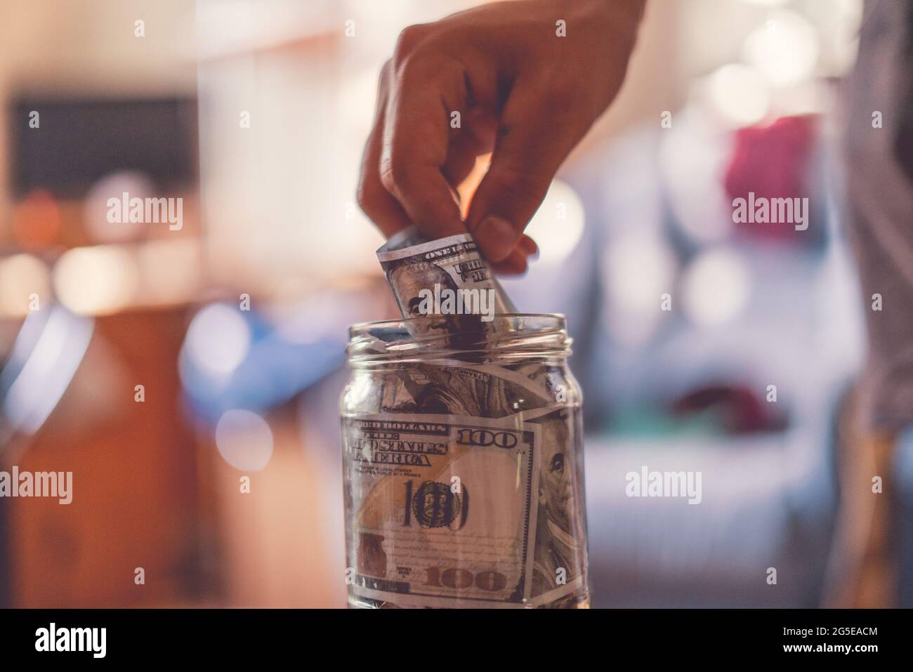 hand put some money in the glass bank with savings Stock Photo - Alamy