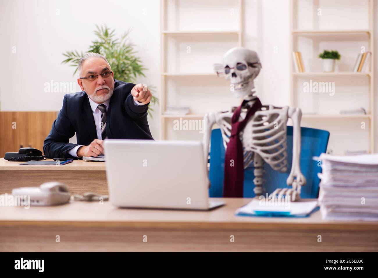 Dead employee working in the office in funny concept Stock Photo - Alamy