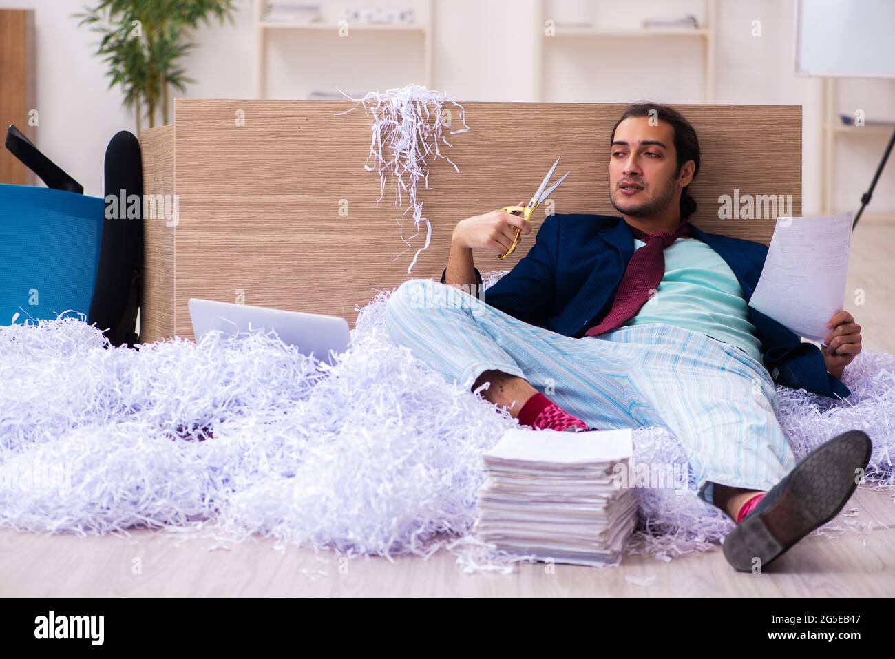 Young businessman employee and a lot of cut papers in the office Stock ...