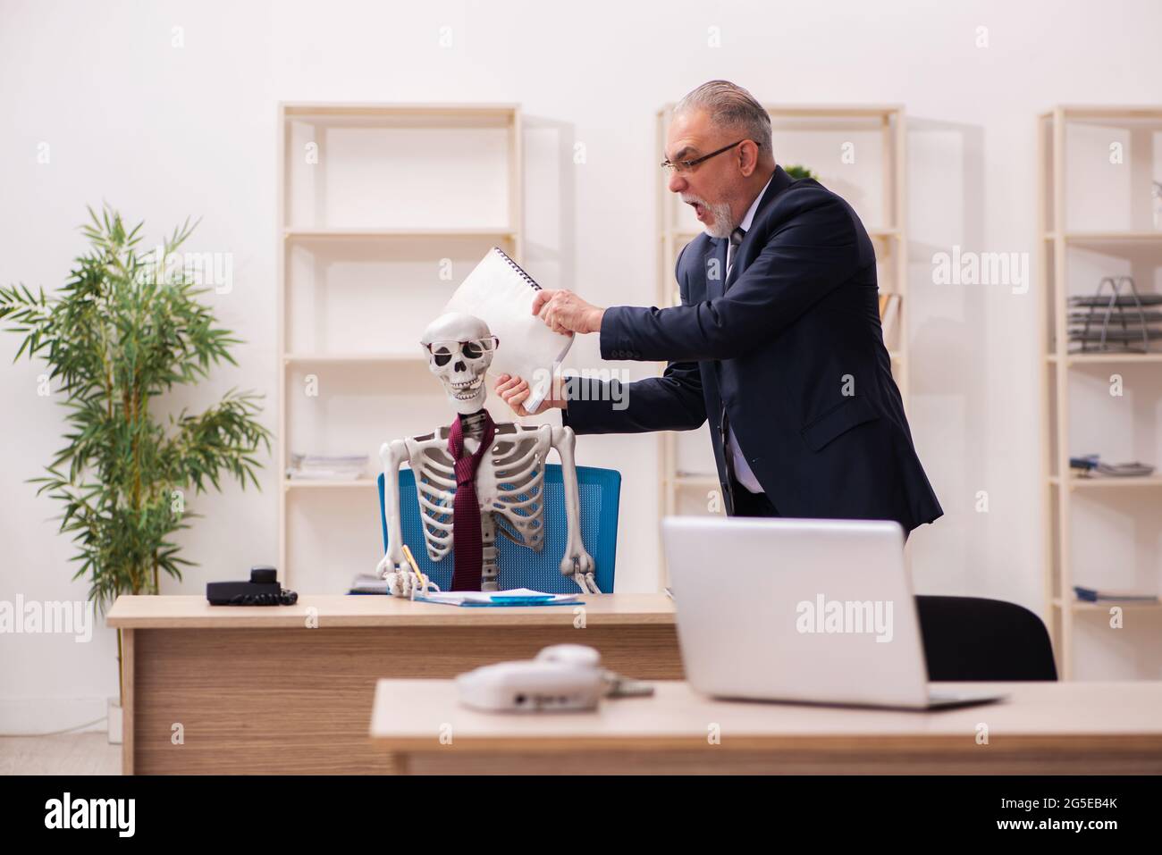 Dead employee working in the office in funny concept Stock Photo - Alamy