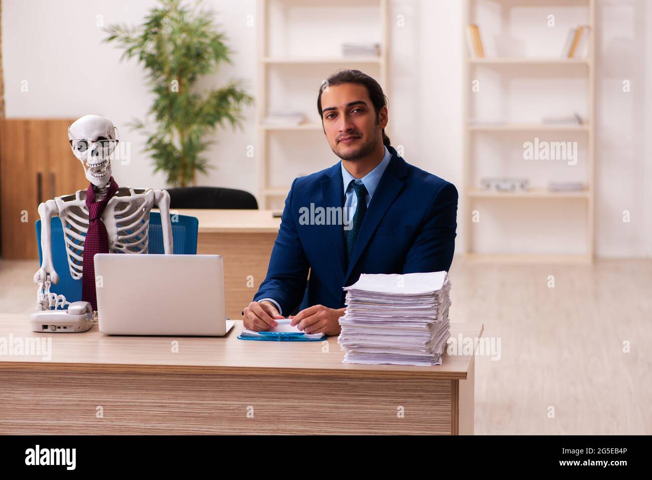 Dead employee working in the office in funny concept Stock Photo - Alamy