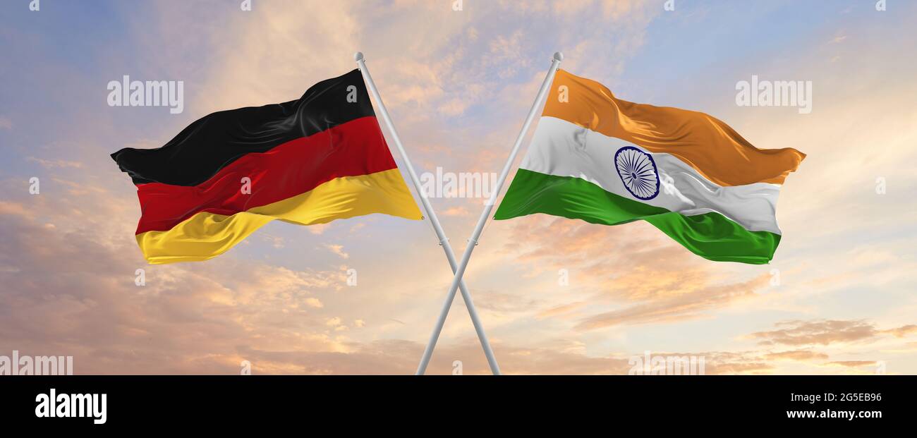 flags of Germany and India waving in the wind on flagpoles against sky ...