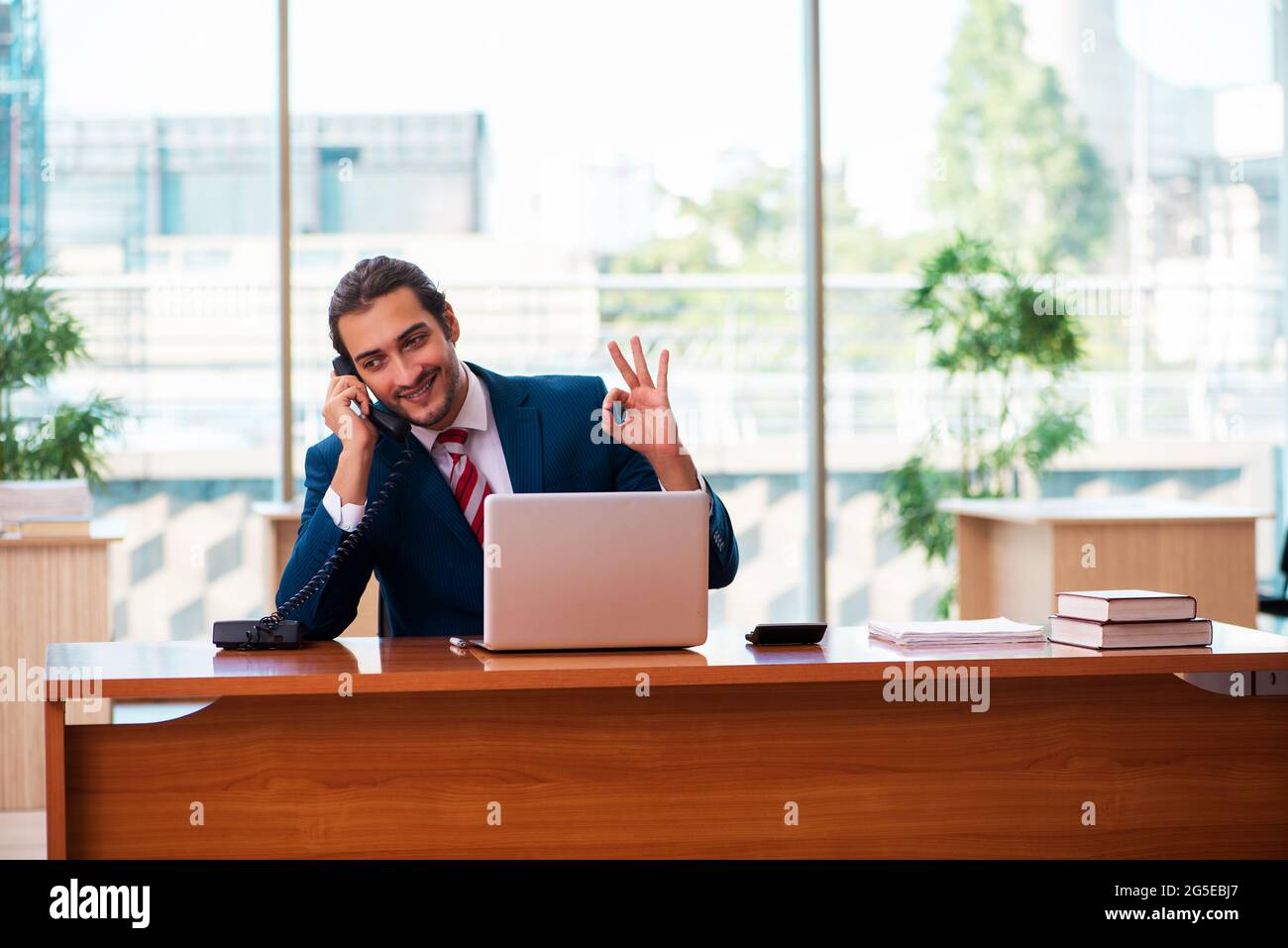 Young attractive male employee working in the office Stock Photo - Alamy
