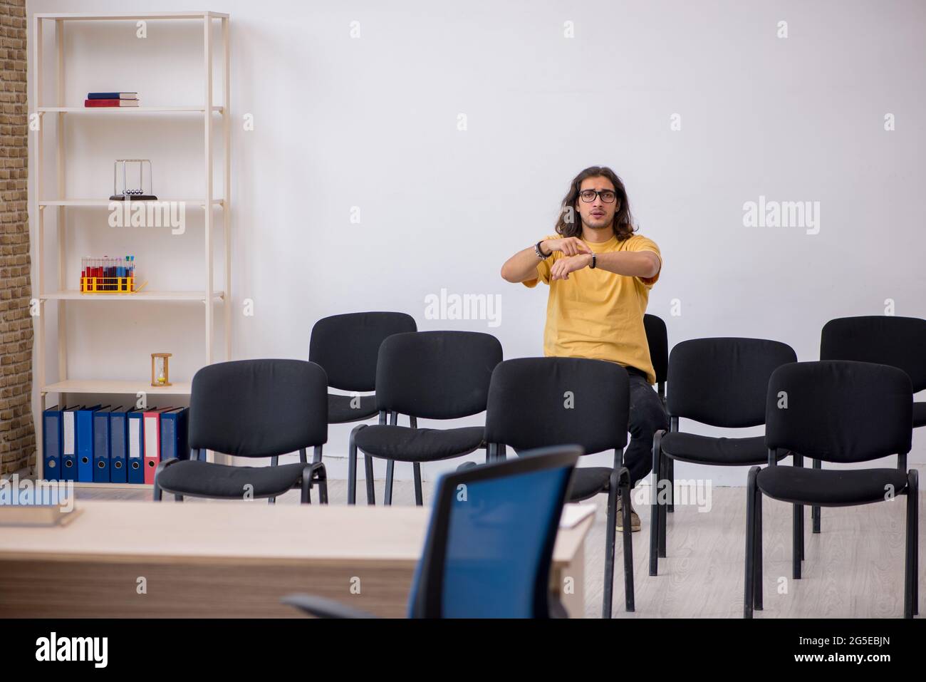 Young student waiting for teacher in the classroom Stock Photo - Alamy