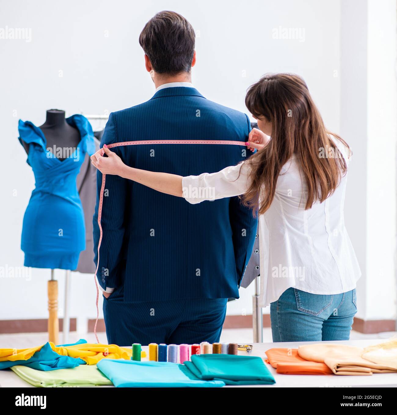 The professional tailor taking measurements for formal suit Stock Photo ...