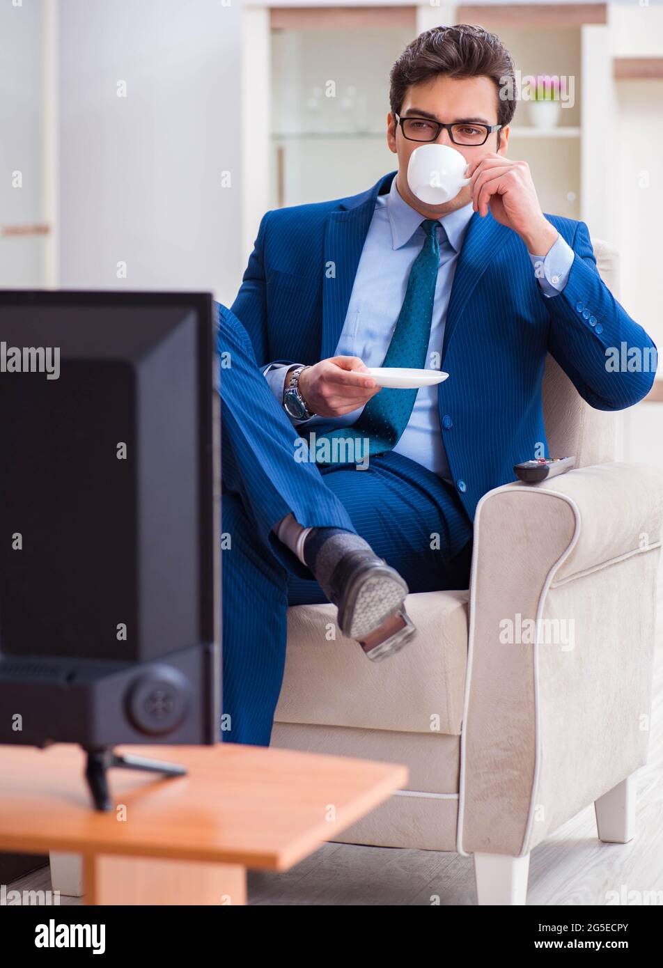 The businesman watching tv in office Stock Photo - Alamy
