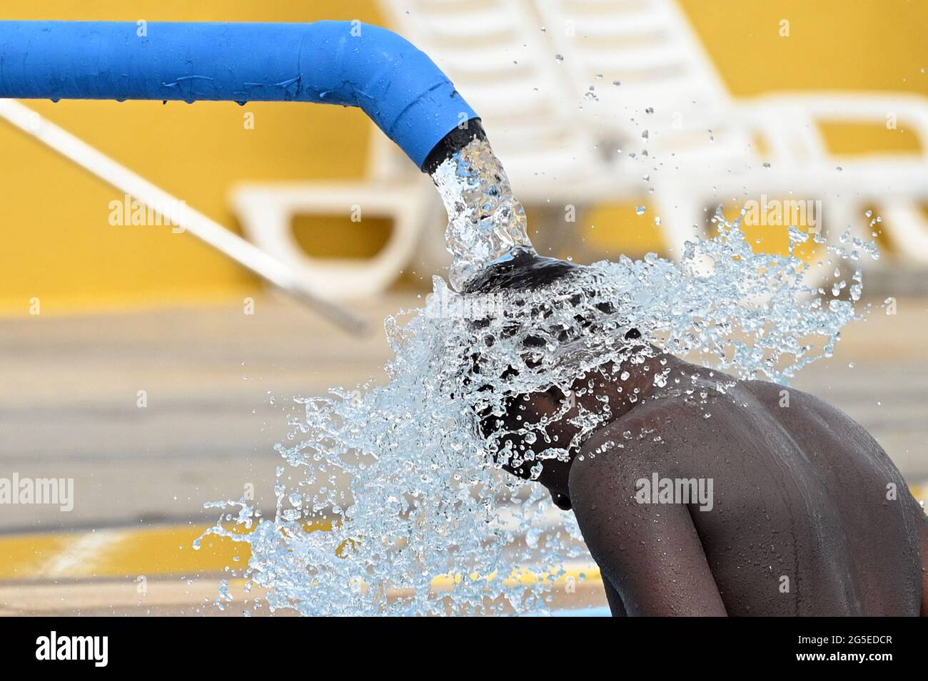 A young man sticks his under a water spout at the Kosciuszko pool as ...