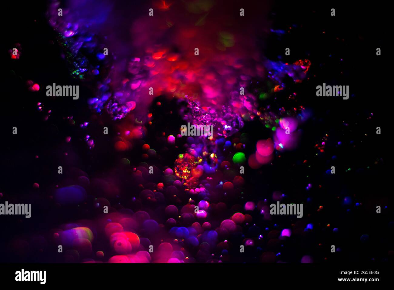 Colored water texture. Splashes of water lit in different colors. Close ...