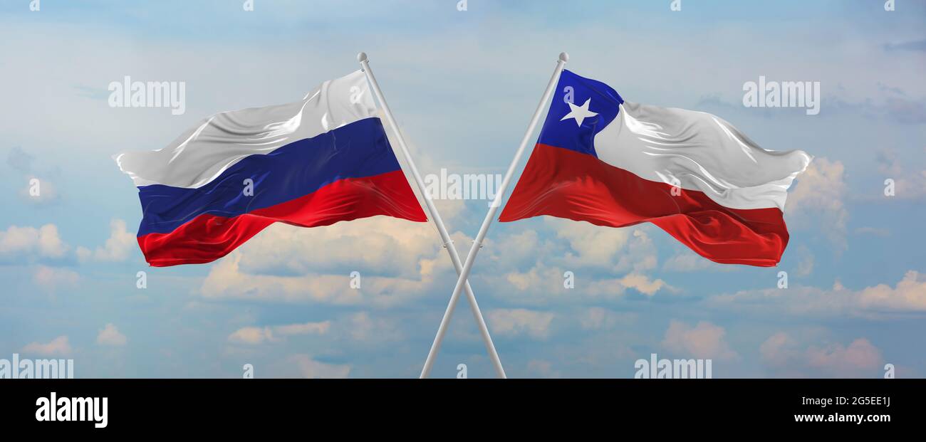 flags of Russia and Chile waving in the wind on flagpoles against sky ...