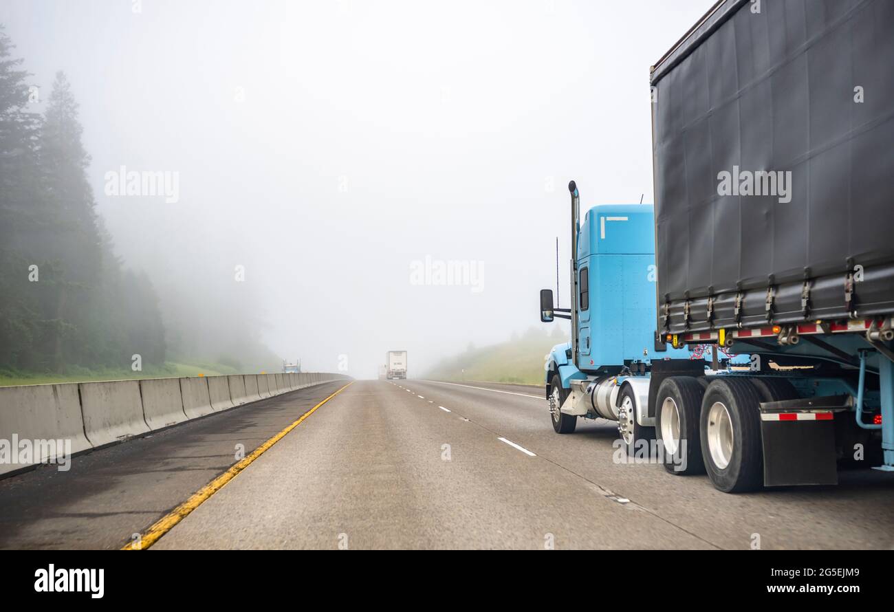 Blue big rig long haul semi truck transporting commercial cargo in dry ...