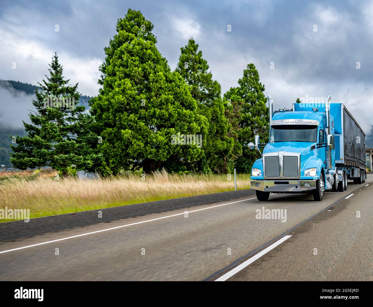 Blue big rig long haul day cab semi truck transporting commercial cargo ...
