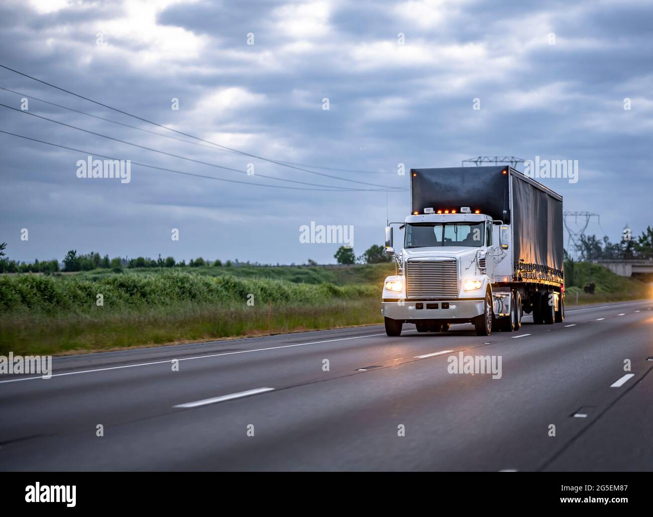 White big rig day cab industrial semi truck with turned on headlight ...