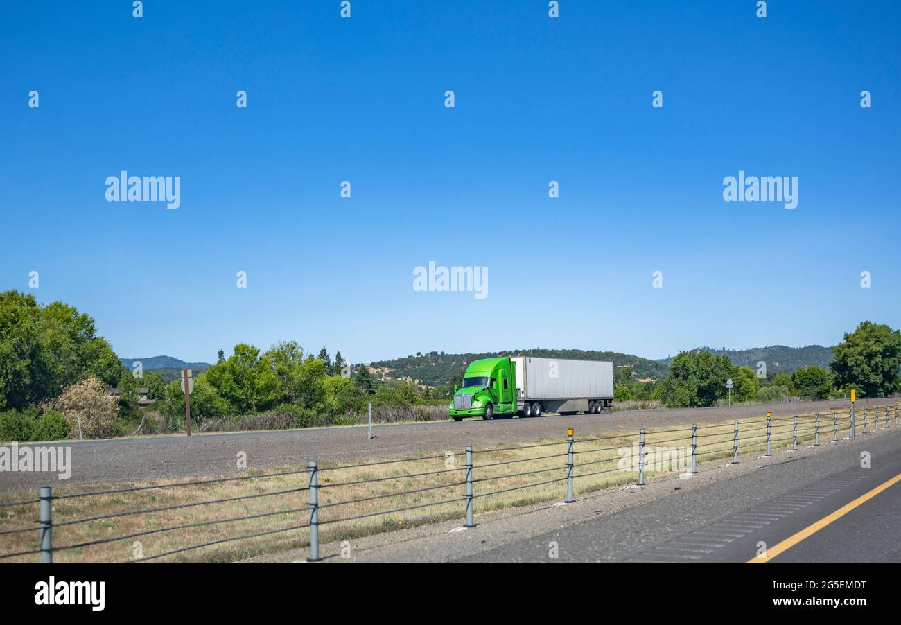 Green big rig long haul industrial semi truck tractor transporting ...