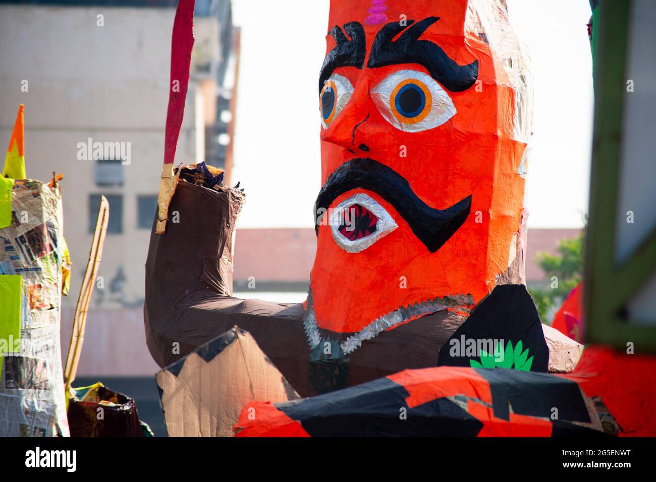 zoomed in shot of red color faced paper mache effigy of the demon king ...