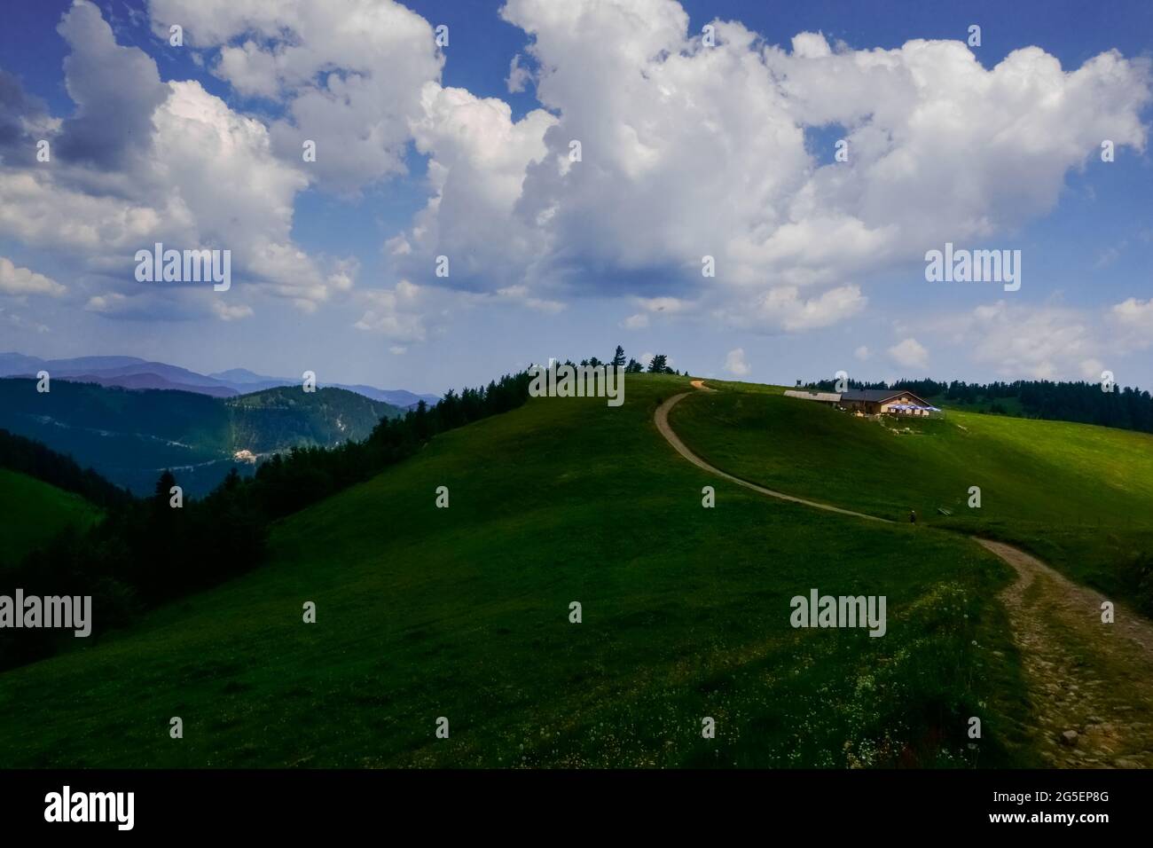long curvy path on a wonderful green hill in the mountains while hiking ...