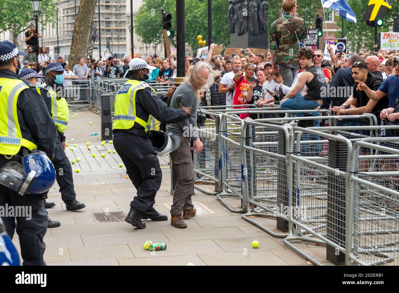 London, UK. 26th June, 2021. A protester jumps over the crowd barriers ...
