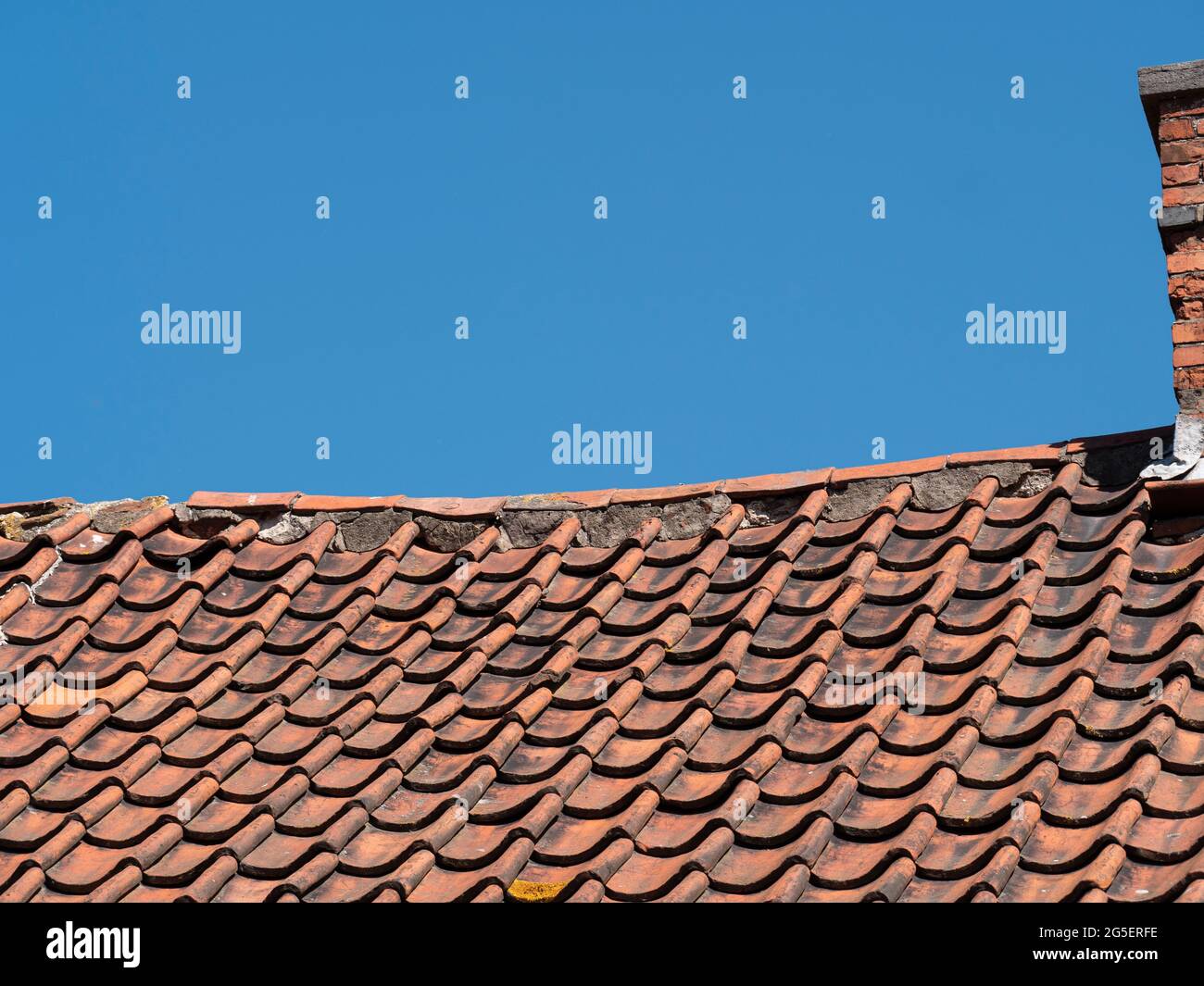 Roof with red roof tiles that is sinking in the middle Stock Photo - Alamy