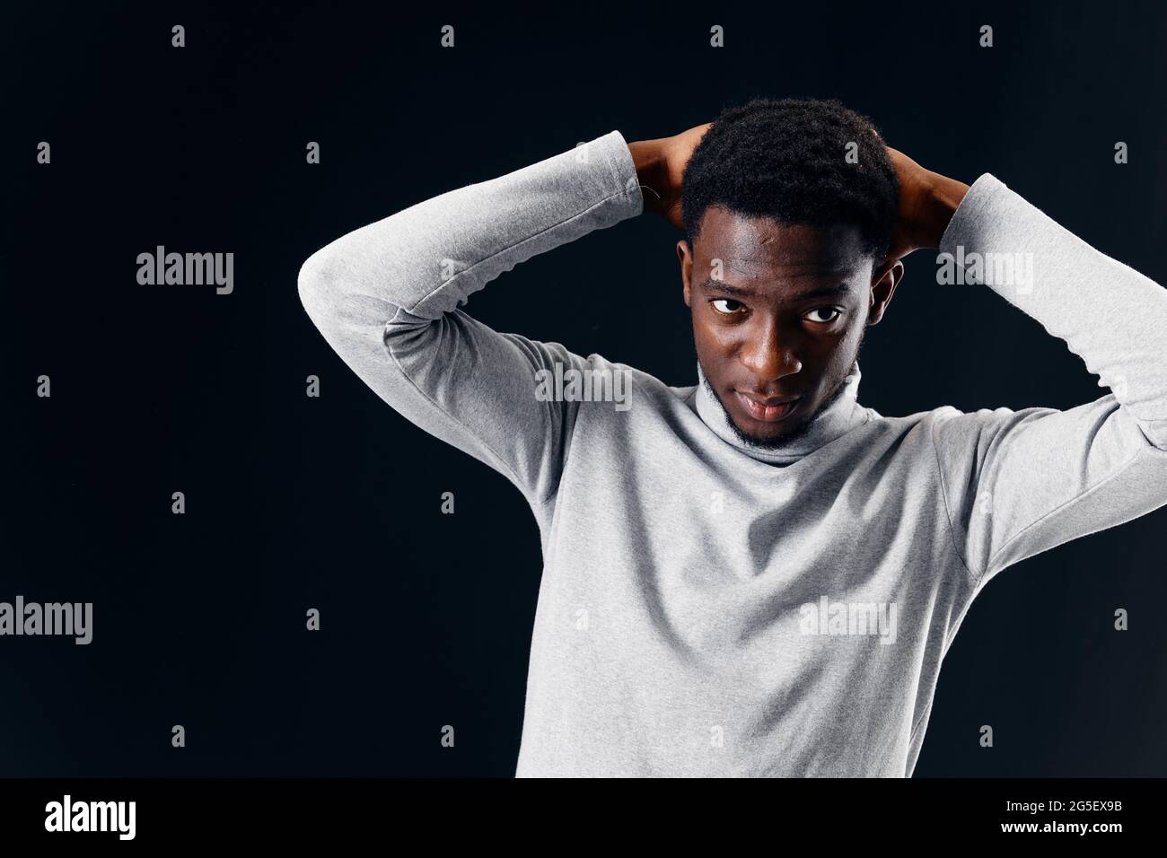 handsome man african appearance hands behind head gray sweater cropped ...