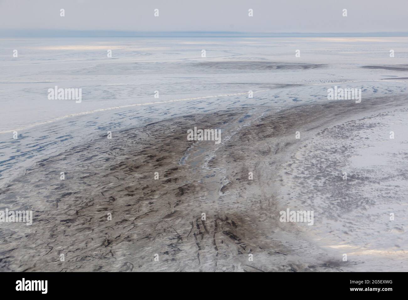 An elevated pipeline running above ground and the frozen tundra from ...