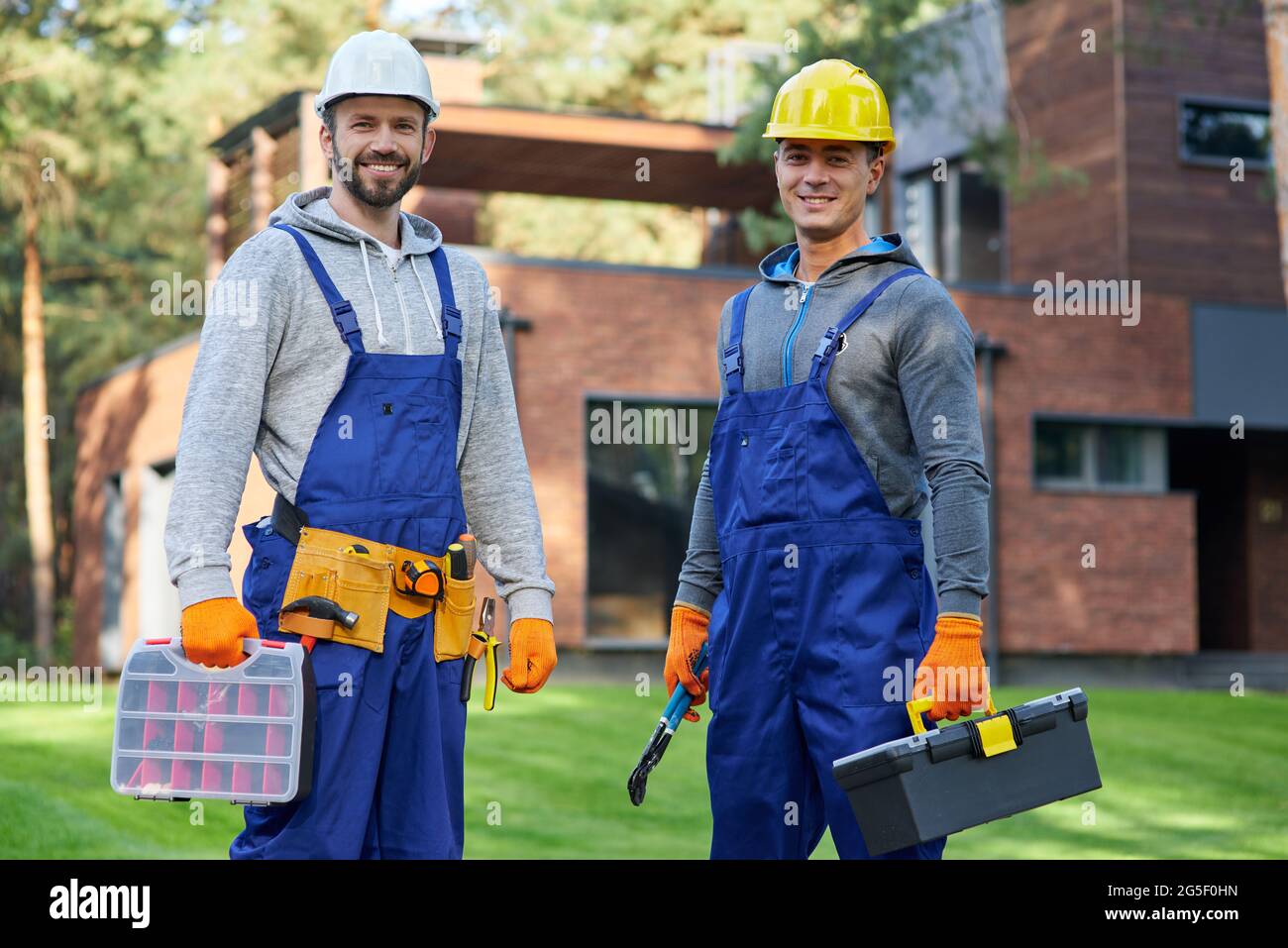 Rely on us. Two positive handsome young male engineers in hard hats ...